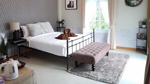 Quarto moderno com cama, mesa de cabeceira, luminária e uma estátua decorativa de cavalo.
