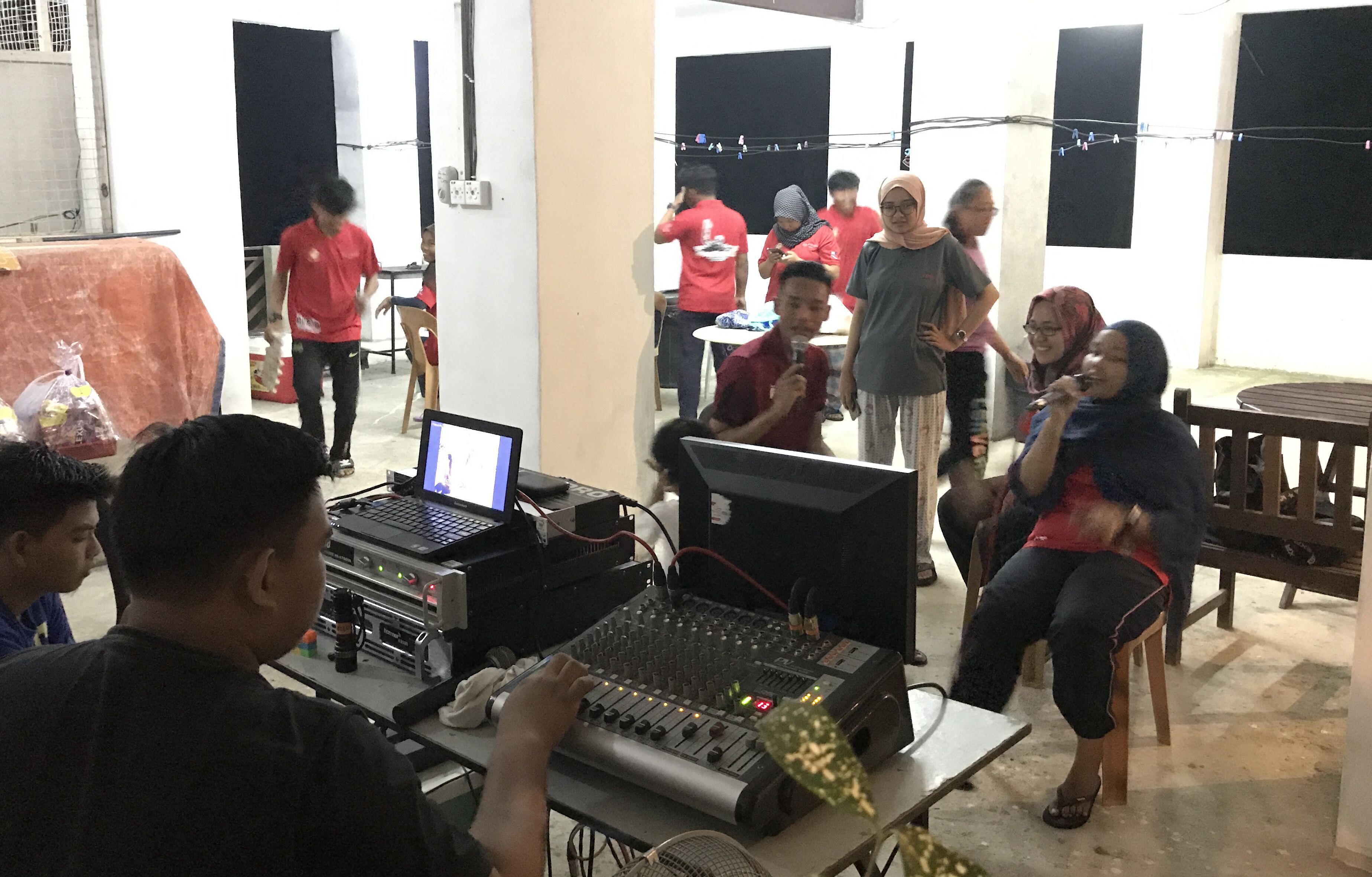 Um quarto com equipamento de DJ, mesas e cadeiras.