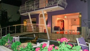 Um edifício moderno com varanda, piscina pequena e área de estar externa.