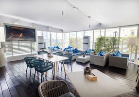 Um quarto espaçoso com uma televisão grande, assentos confortáveis e vista para a cidade.