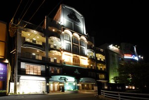 A multi-story hotel with illuminated balconies and signage for "Hotel Atlantis" and "Hotel Original."
