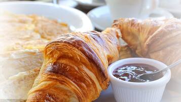 Um croissant e uma pequena tigela de geleia.