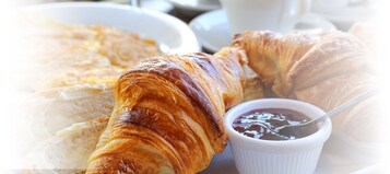 Um croissant e uma pequena tigela de geleia.