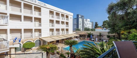 Um hotel com várias varandas, piscina e áreas de estar ao ar livre.