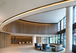 Um hall amplo com teto curvo, assentos modernos e grandes janelas.