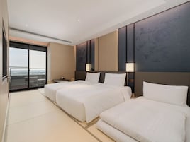Quarto de hotel com duas camas, varanda e vista para a cidade.