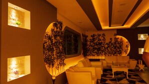 Um interior moderno com sofás, uma mesa e painéis decorativos na parede.