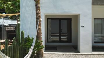 Um edifício moderno com design minimalista, apresentando uma grande porta de vidro e o número '15B' na parede.
