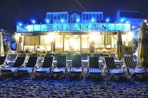 Praia particular, espreguiçadeiras, guarda-sóis