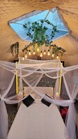 Uma tenda com cama, plantas penduradas e luzes de cordão.
