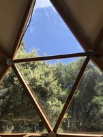 Quarto com design geométrico na janela, permitindo a entrada de luz natural.