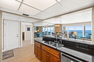 Cozinha espaçosa com uma ilha grande, área de jantar com vista para o oceano e um espaço de estar acolhedor com varanda vista para o mar.