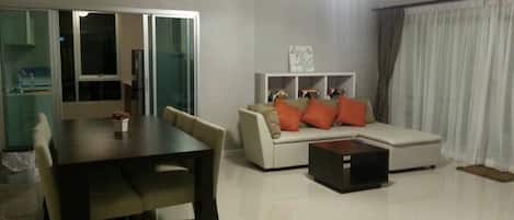 Uma sala de estar moderna com uma mesa de jantar, sofá e mesa de centro.