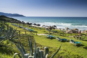 Praia particular, espreguiçadeiras, guarda-sóis 