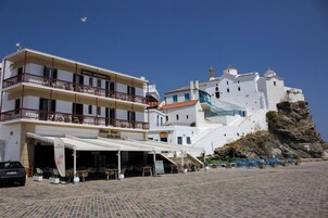 Um hotel com vários andares, área de estar ao ar livre e vista para um edifício branco com uma torre.