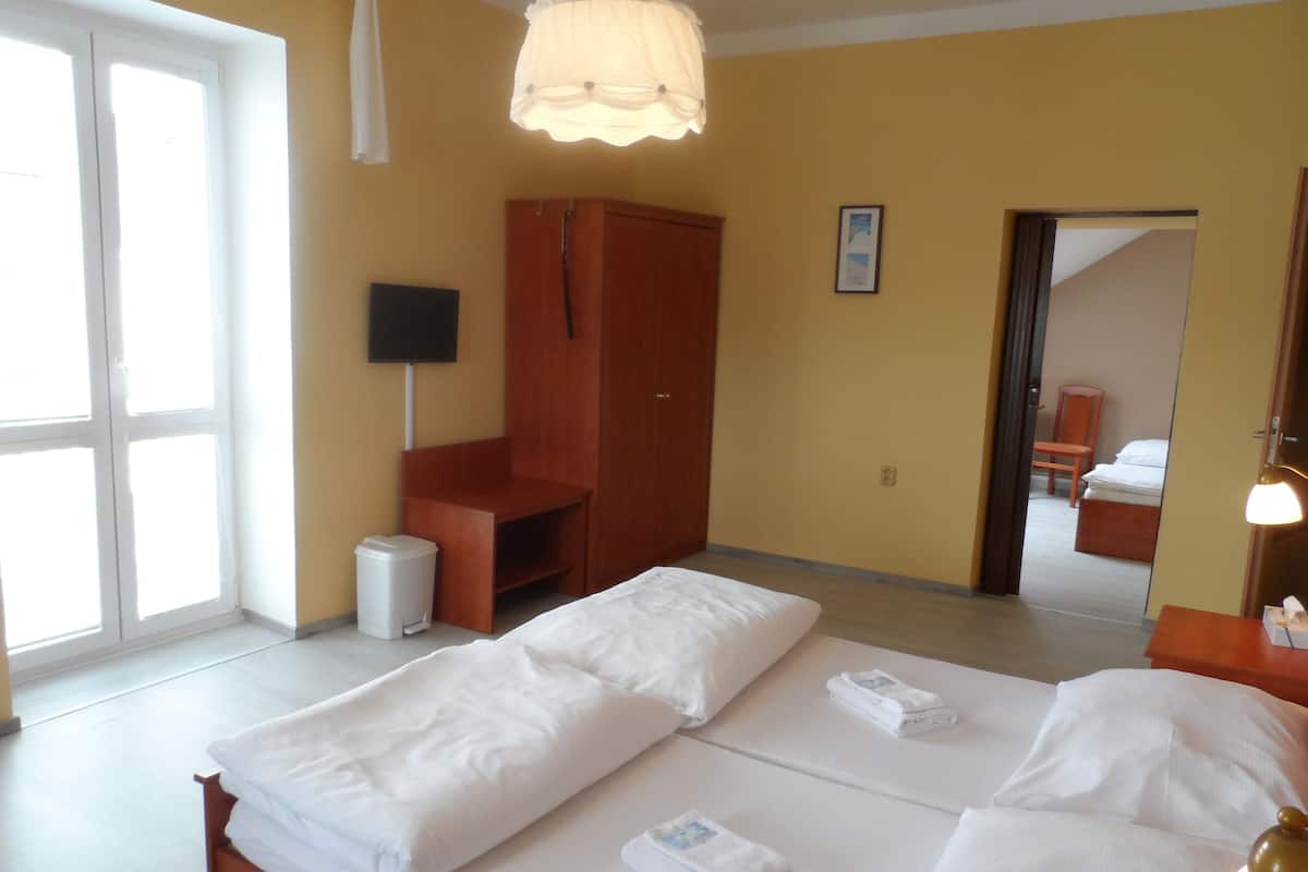 Quarto de hotel com cama, guarda-roupa, escrivaninha e cadeira.