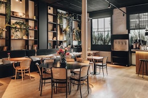 Decoração moderna com área de bar, disposição de assentos e estante com plantas decorativas.
