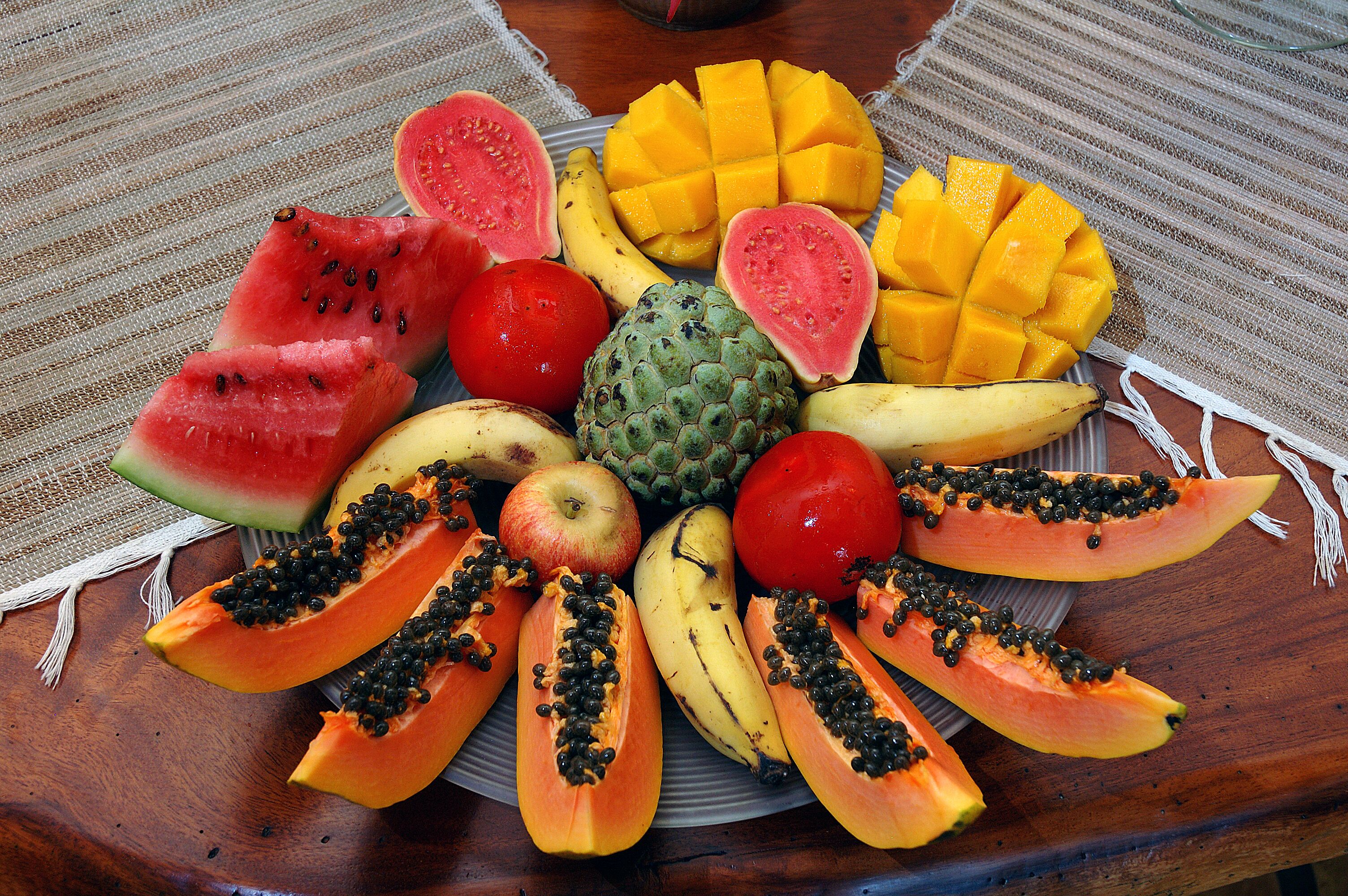 Uma travessa com frutas variadas, incluindo melancia, manga, mamão e abacaxi.