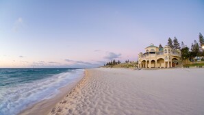 Um imóvel à beira-mar com um edifício grande, com janelas em arco e uma cúpula.