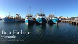 Um porto de barcos de pesca, com vários barcos atracados no cais.