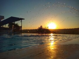 Piscina externa, piscina com cascata, funciona piscina, guarda-sóis
