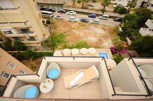 Terraço no telhado com cadeiras de lounge, uma piscina pequena e vista para a rua.