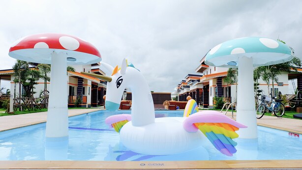 Piscina com decorações de cisne e cogumelo infláveis.
