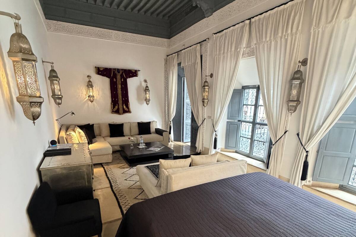 Um quarto com uma cama, um sofá, uma mesa de centro e uma escrivaninha.