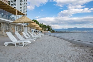 Praia particular, espreguiçadeiras, guarda-sóis
