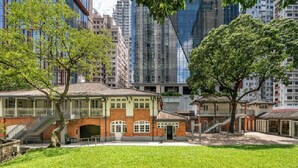 Um edifício tradicional com fachada de tijolos, um pátio central e uma escadaria que leva a um andar superior.