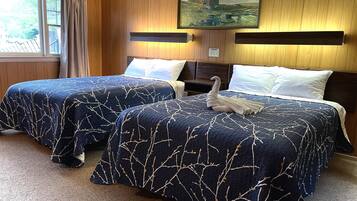 Quarto de hotel com duas camas, um quadro na parede e uma janela com cortinas.