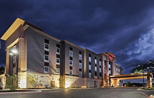Um hotel moderno com fachada de pedra, vários andares e uma entrada acolhedora.