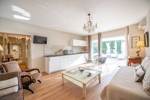 Uma sala de estar moderna com uma mesa de centro de vidro, um sofá e um espaço de jantar com mesa e cadeiras.