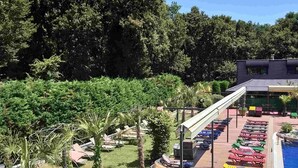 Uma área à beira da piscina com espreguiçadeiras e piscina.
