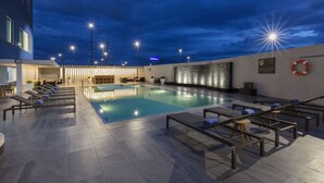 Uma área de piscina com espreguiçadeiras e bar.