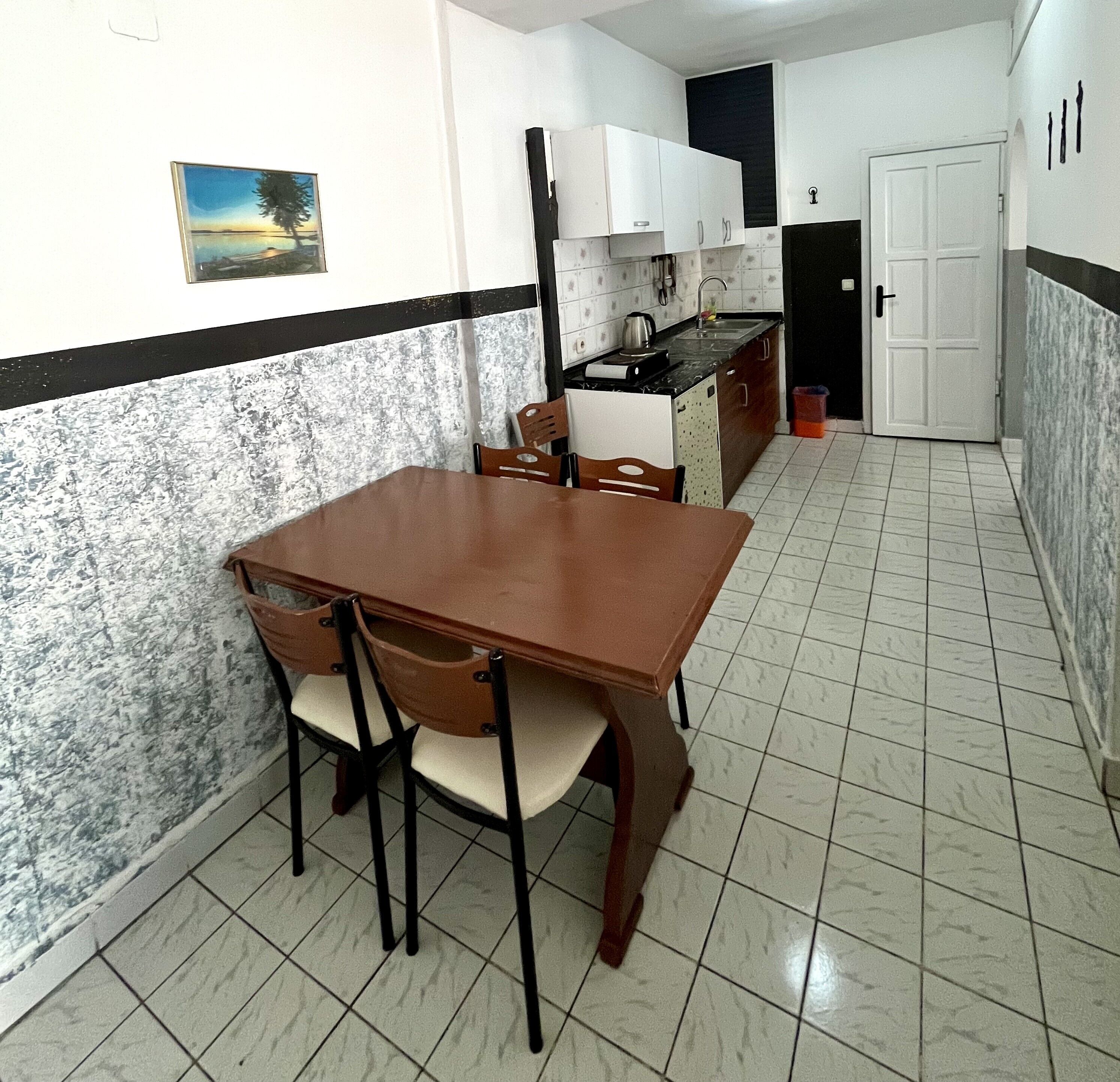 Uma cozinha compacta com mesa e cadeiras, pia e armários.