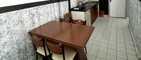 Uma cozinha compacta com mesa e cadeiras, pia e armários.