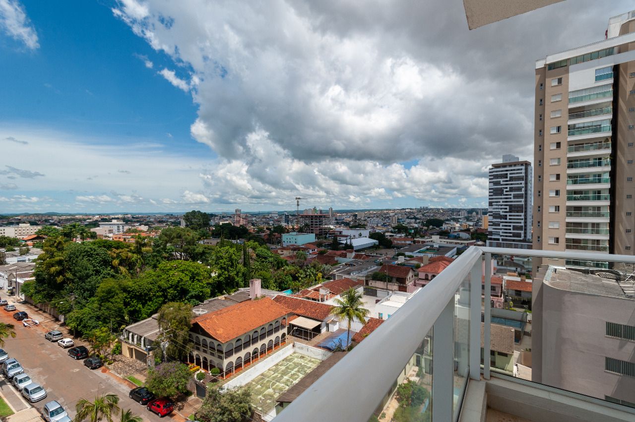 Um edifício alto com vista para o horizonte urbano, incluindo diversos edifícios e um céu claro.