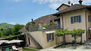 Uma área de piscina com uma piscina azul cristalina, um deck de madeira e móveis de exterior.