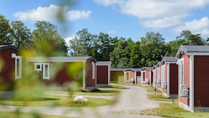 Uma fileira de casas móveis vermelhas com um caminho de cascalho passando por elas.