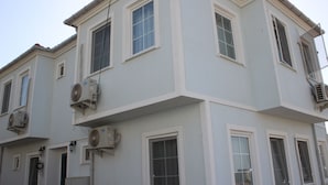 Um edifício com vários andares, várias janelas e aparelhos de ar condicionado.