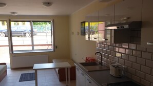 Uma cozinha moderna com janela, radiador, pia e fogão.
