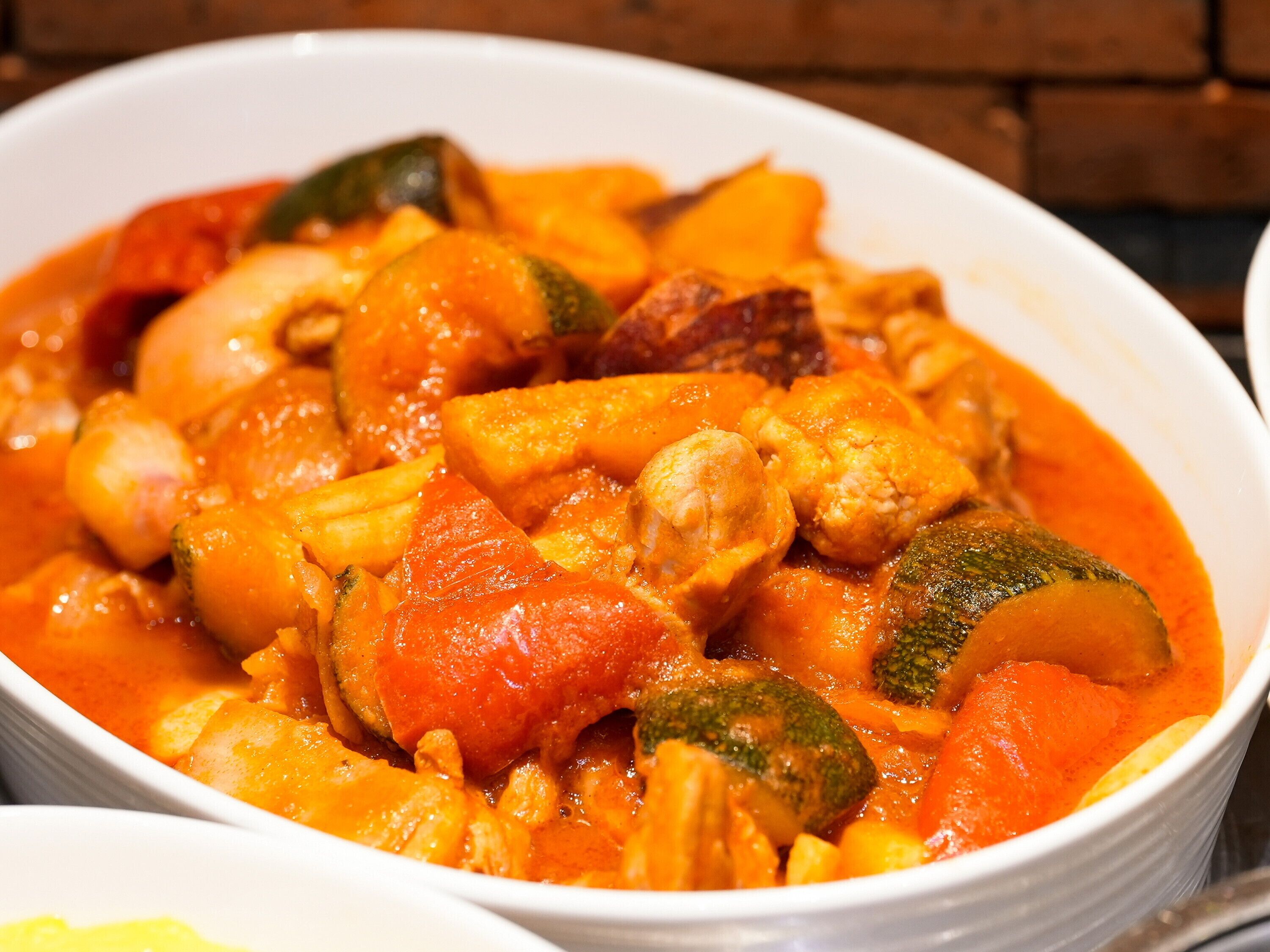 Uma tigela de ensopado com vários legumes e pedaços de carne.