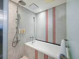 Casa de banho moderna com lavatório branco, chuveiro com cabeça de chuveiro de chuva e parede com padrão de favo de mel.