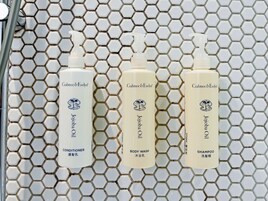 Três produtos Crabtree & Evelyn apoiados em uma parede revestida de azulejos.