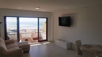 Apartamento Premium, vista para o oceano, junto ao mar | Sala de estar | TV de ecrã plano