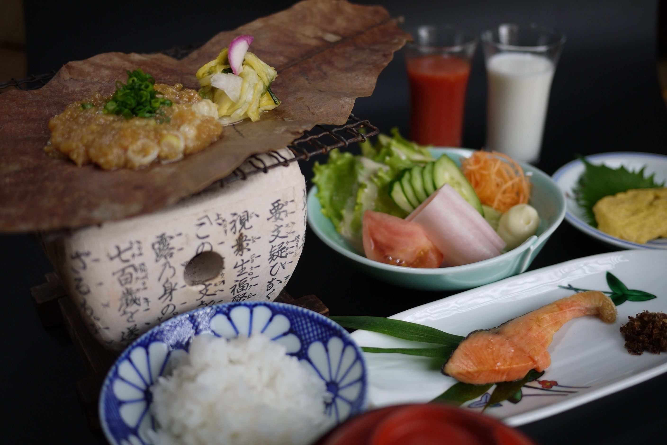 Uma refeição japonesa tradicional com diversos pratos, incluindo arroz, peixe e legumes.