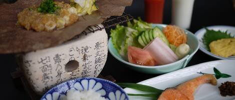 Uma refeição japonesa tradicional com diversos pratos, incluindo arroz, peixe e legumes.