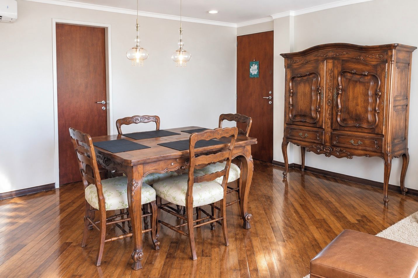Uma sala de jantar com uma mesa de madeira, cadeiras e um armário.