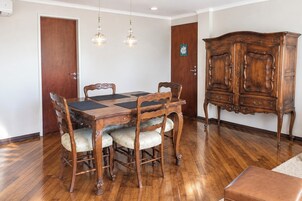 Uma sala de jantar com uma mesa de madeira, cadeiras e um armário.